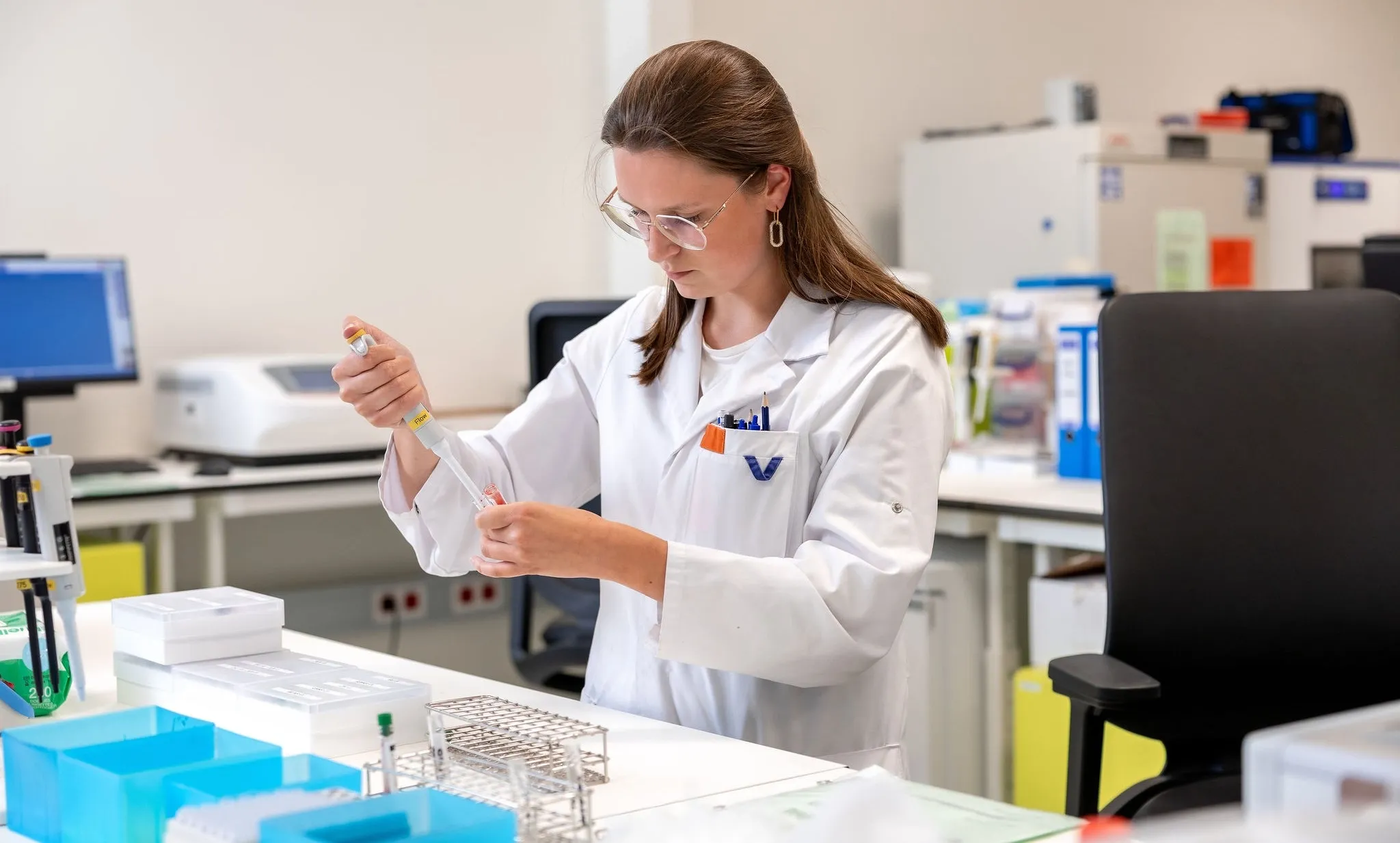 Medewerker lab pipetteert